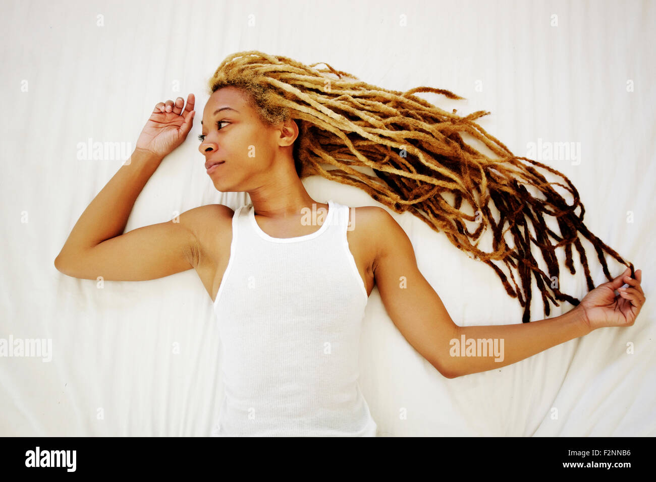 Black woman with dreadlocks laying on bed Stock Photo - Alamy