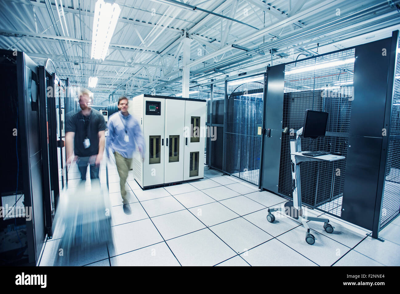 Blurred view of technicians pushing cart in server room Stock Photo - Alamy