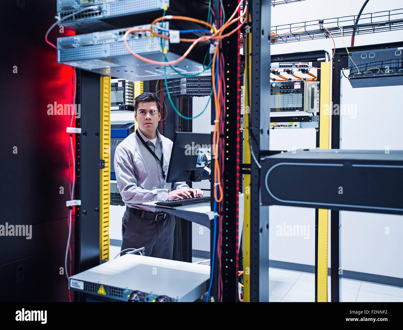 Hispanic technician using computer in server room Stock Photo - Alamy