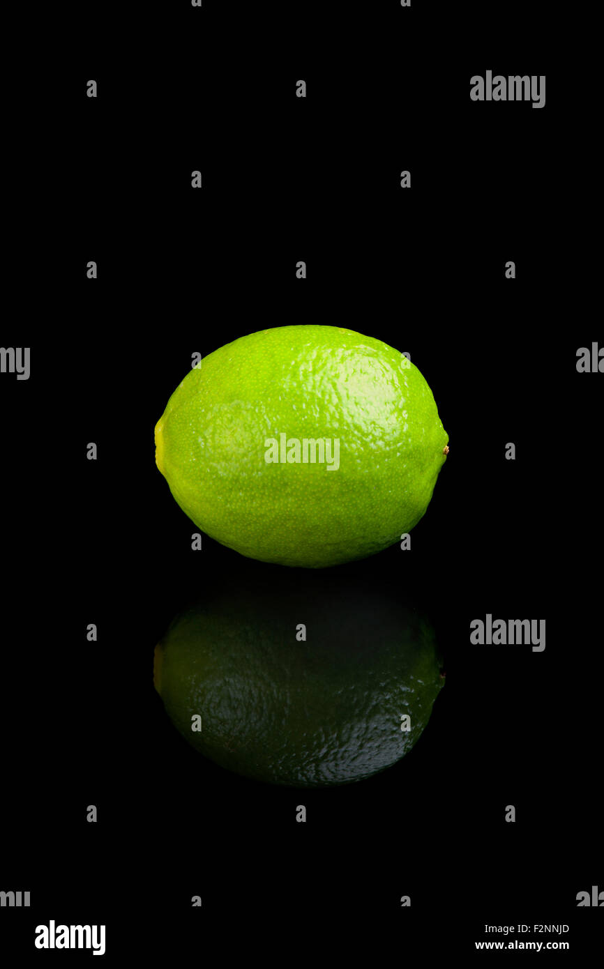 A lime on a black reflective background Stock Photo - Alamy