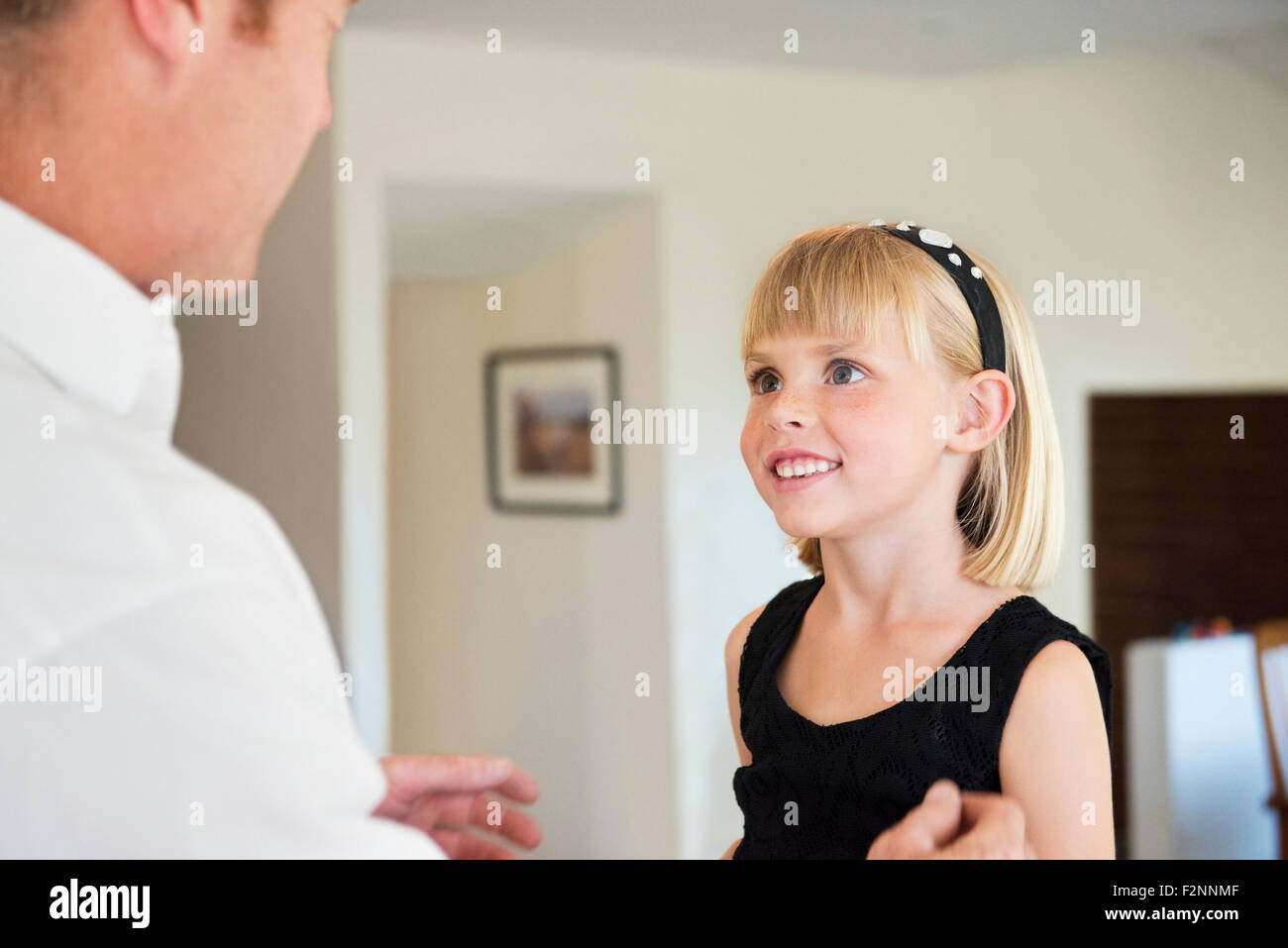 Caucasian father and daughter talking in living room Stock Photo - Alamy