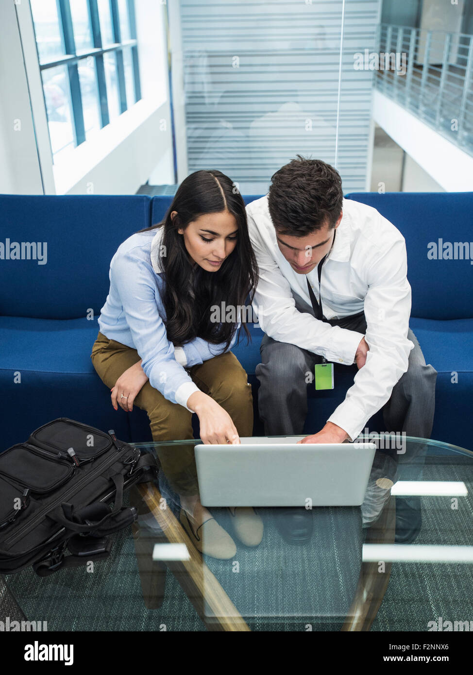 Business people using laptop in office lobby Stock Photo - Alamy