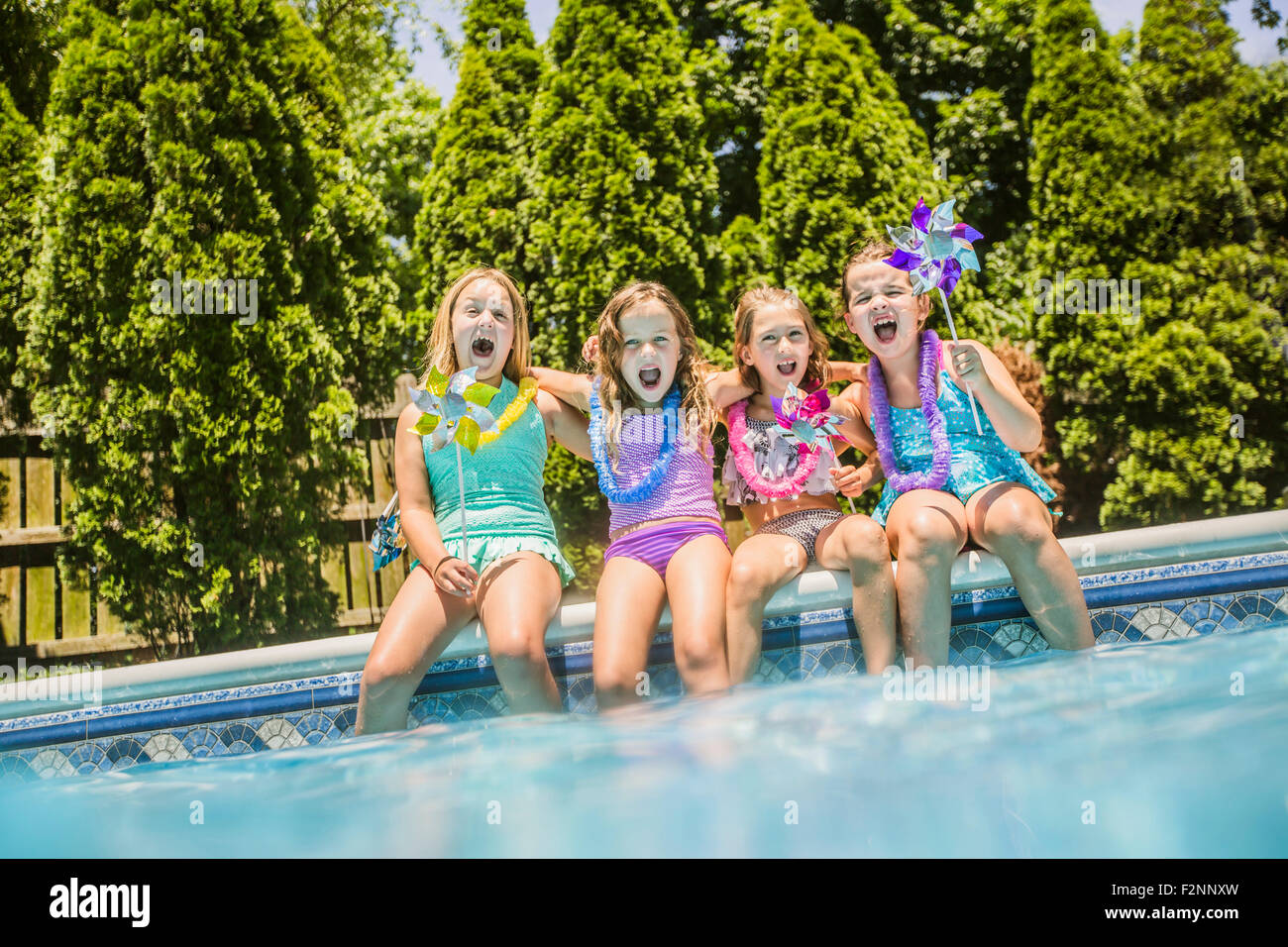 Caucasian girls cheering at swimming pool Stock Photo - Alamy