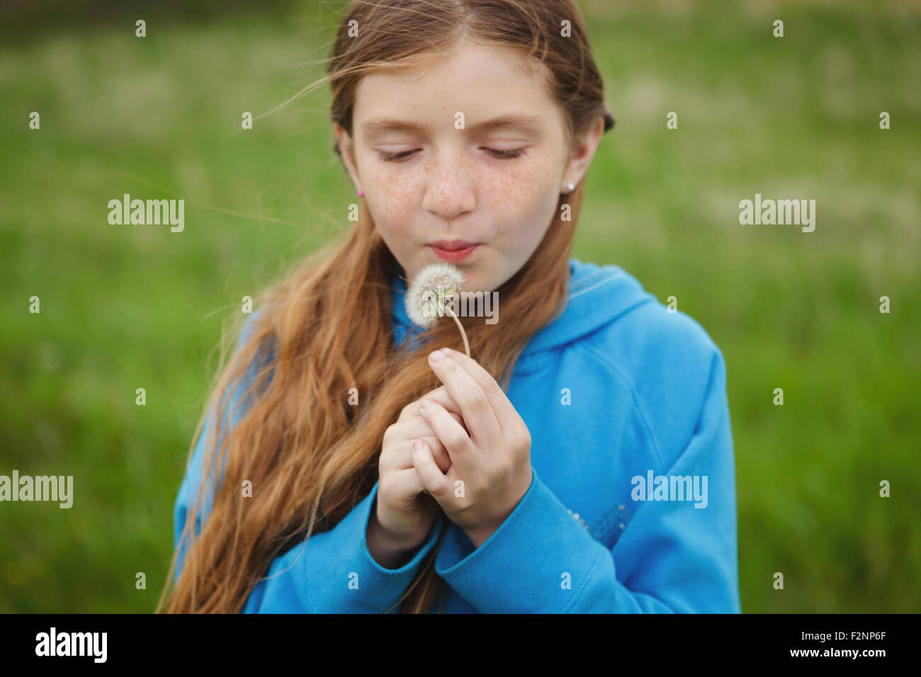 Caucasian girl blowing dandelion outdoors Stock Photo - Alamy