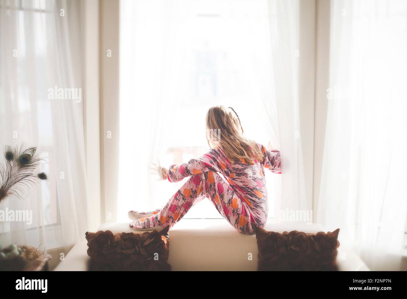 Caucasian girl sitting in window Stock Photo - Alamy