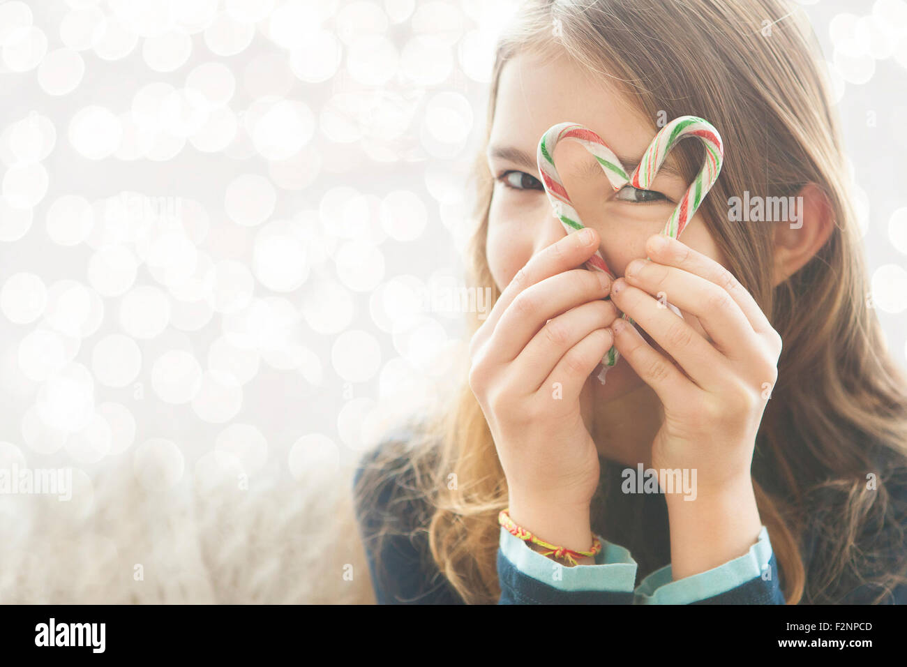 Caucasian girl looking through heart-shape with candy canes Stock Photo ...