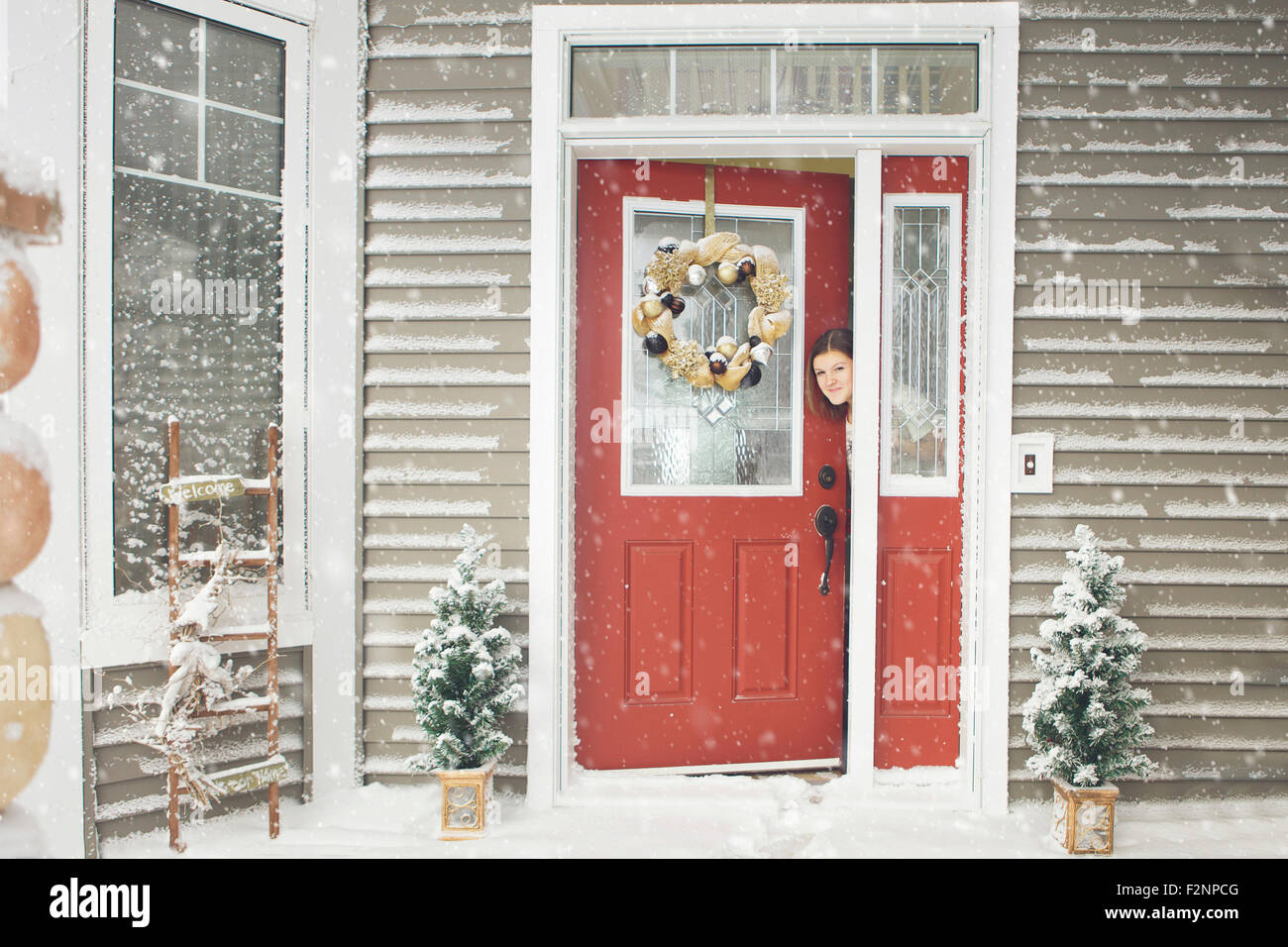 Caucasian woman opening door to snow Stock Photo - Alamy