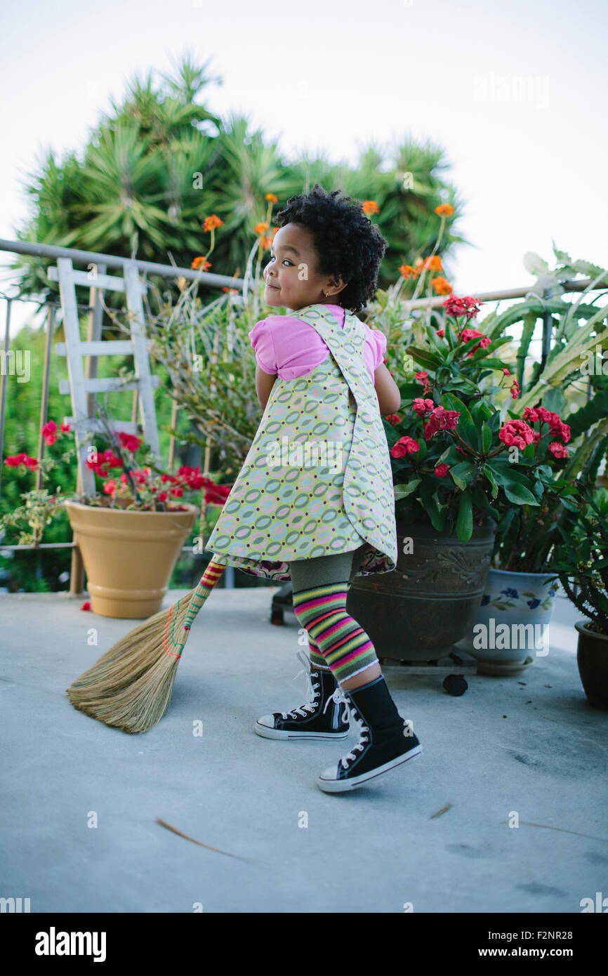 Girl sweeping patio with broom Stock Photo - Alamy