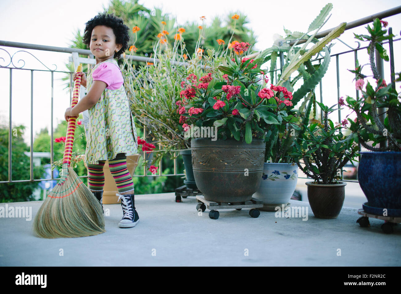 Girl sweeping patio with broom Stock Photo - Alamy