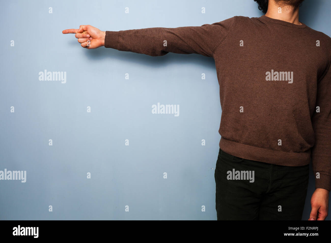 a young man is pointing to the left hand side of the frame Stock Photo ...