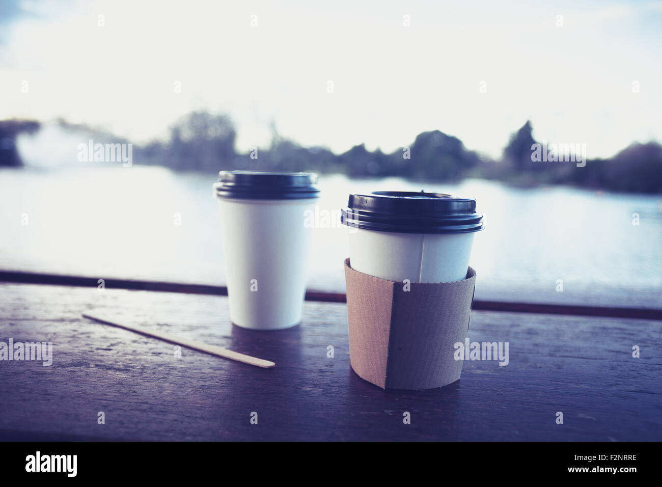 Two paper cups on table by the water Stock Photo - Alamy