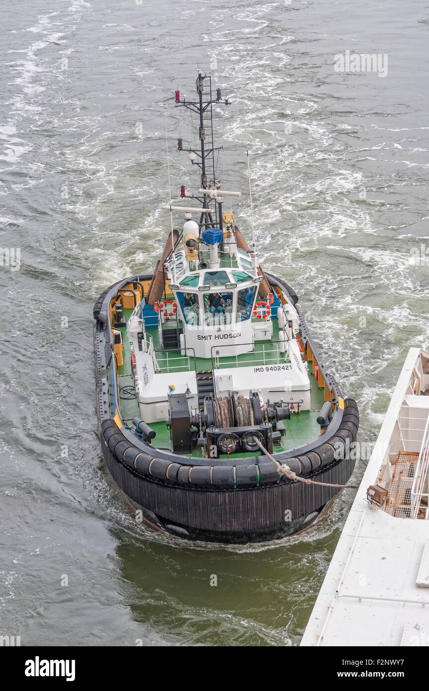Tug boat moving into position to guide ship into harbour Stock Photo ...