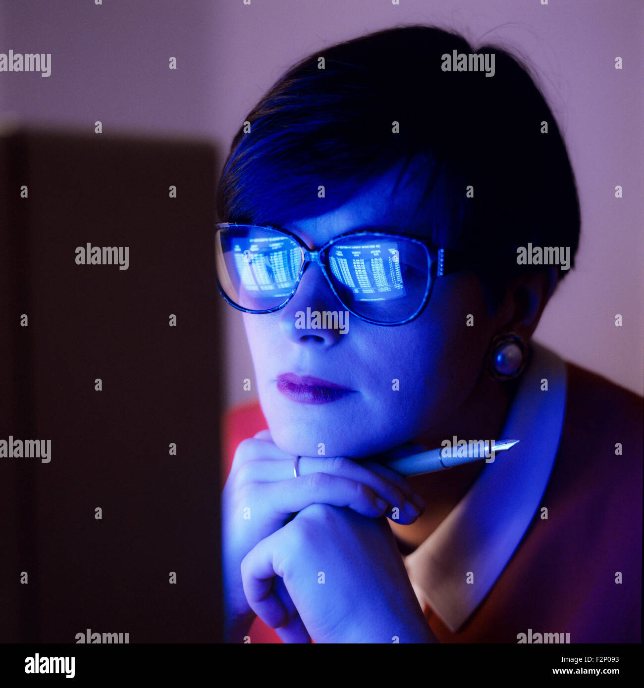 Thoughtful businesswoman with computer screen reflected in her glasses ...