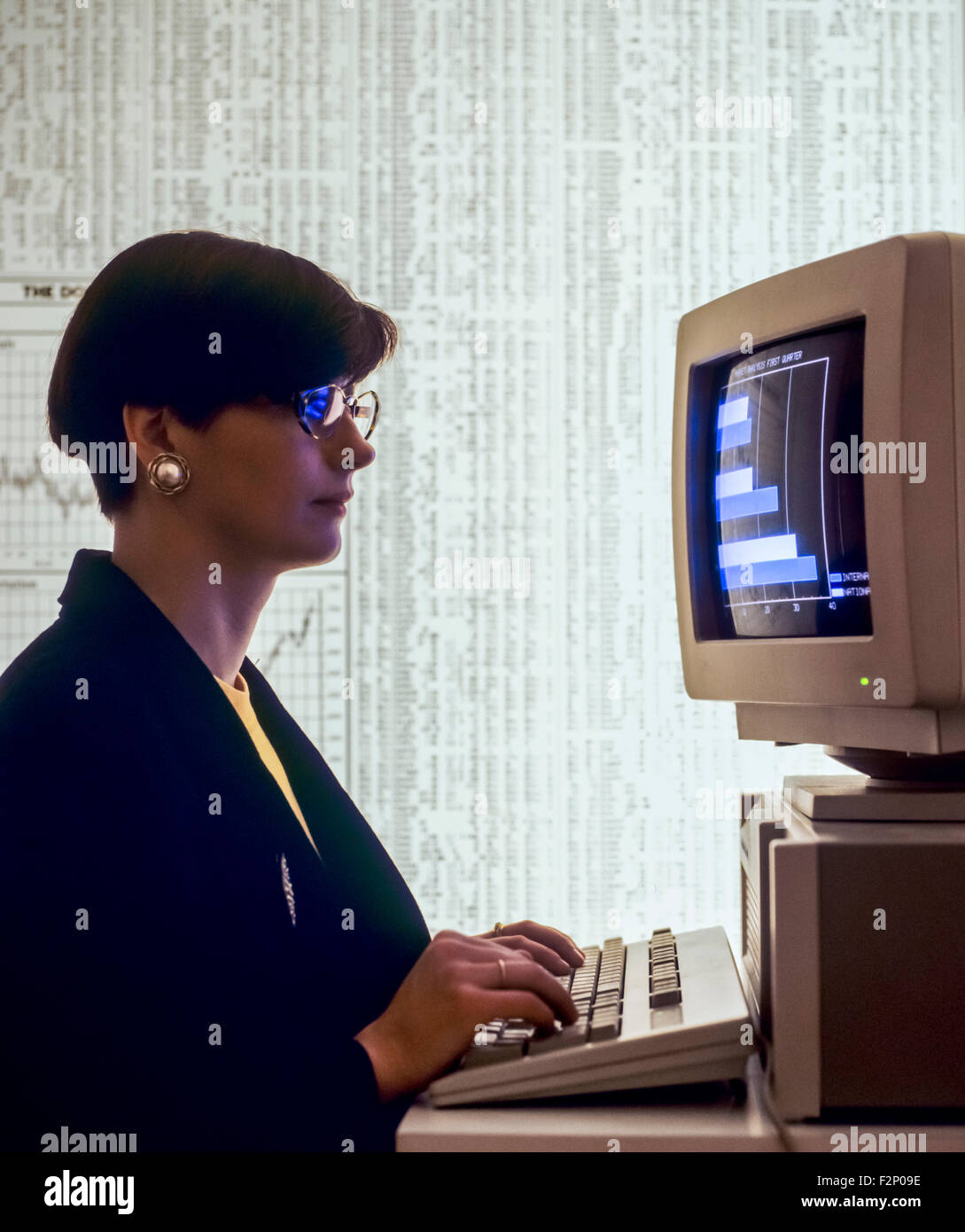 Businesswoman studying statistics graph on computer and stock market ...