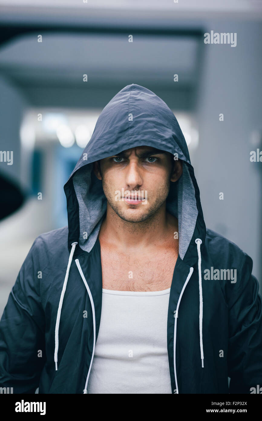 Portrait of angry looking man wearing black hooded jacket Stock Photo ...