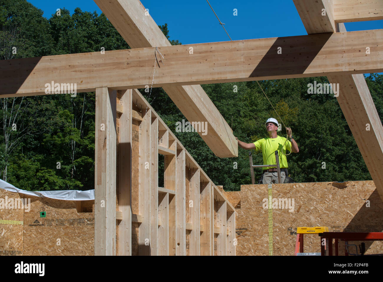 Carpenter installs wooden roof rafters on Leed Platinum Common Ground ...