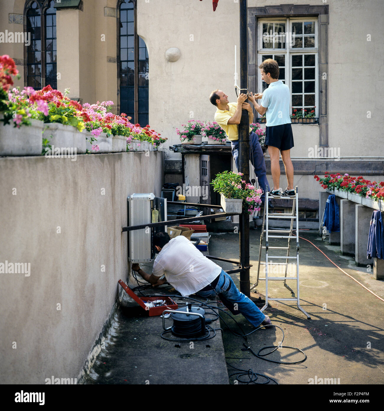 Telecom engineers installing a cellular telephone relay on ancient ...