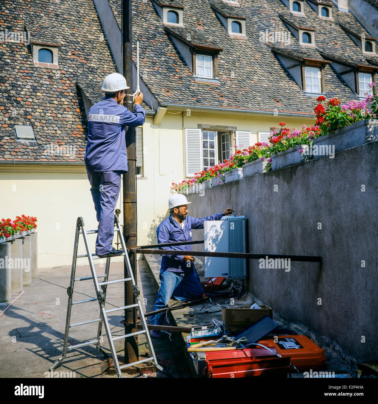 Telecom engineers installing a cellular telephone relay on ancient ...