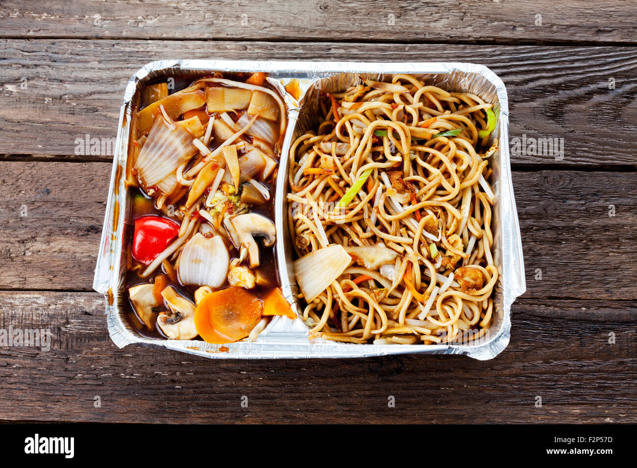 Fried noodles and vegetables in aluminium tray on wood Stock Photo - Alamy
