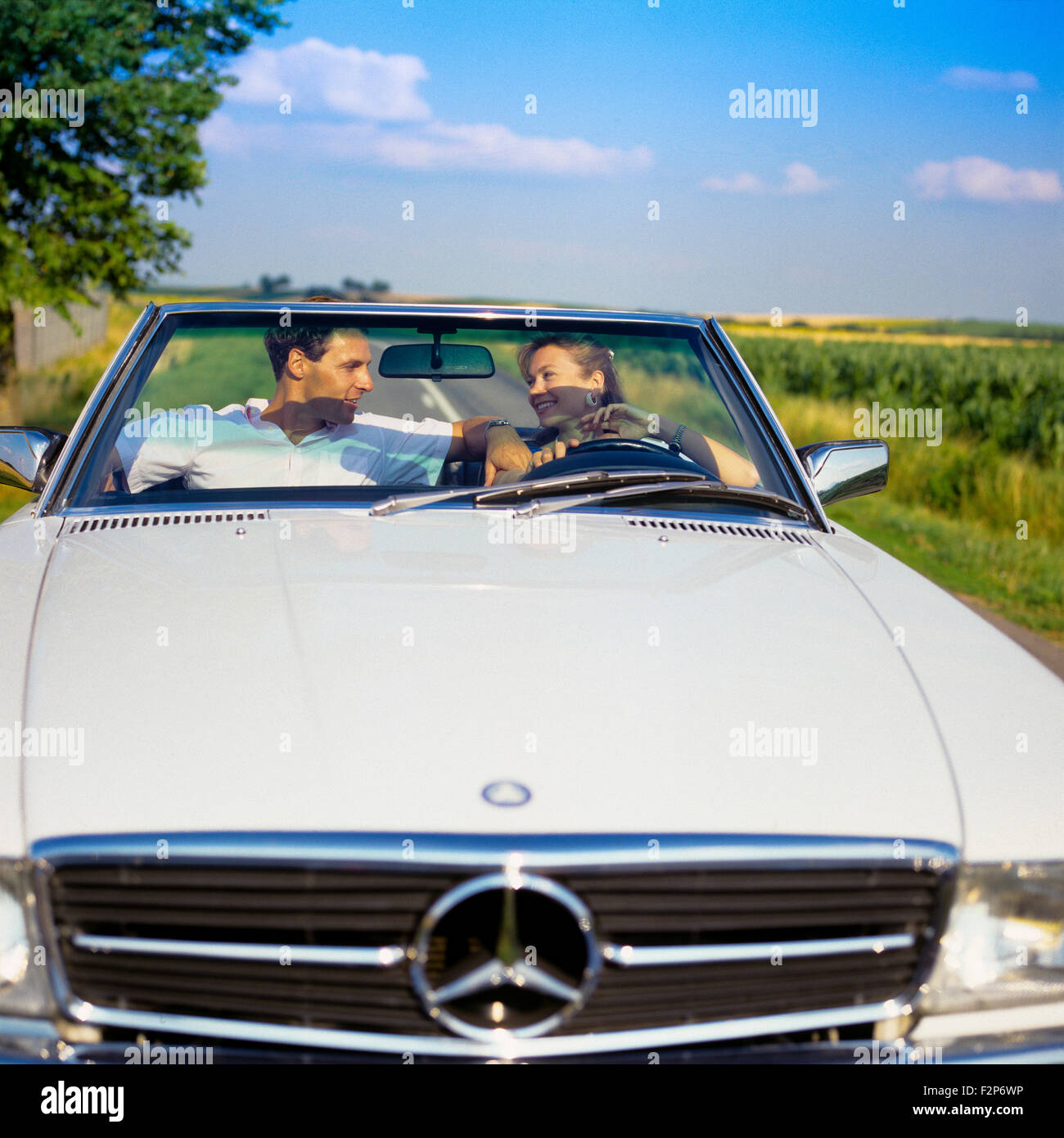Couple driving a Mercedes convertible car on country road, Alsace ...