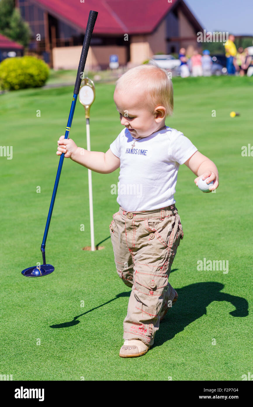Cute little baby boy playing golf on a field outdoor Stock Photo - Alamy