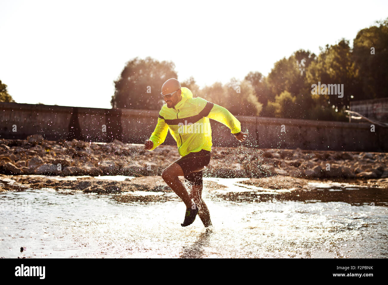Man in sports wear running in water Stock Photo - Alamy