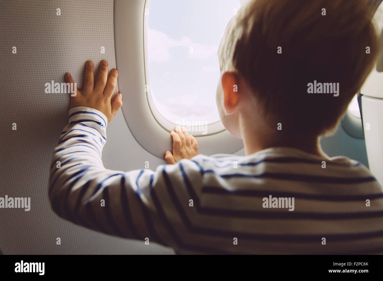 Little boy looking out of window while flying on an airplane Stock ...