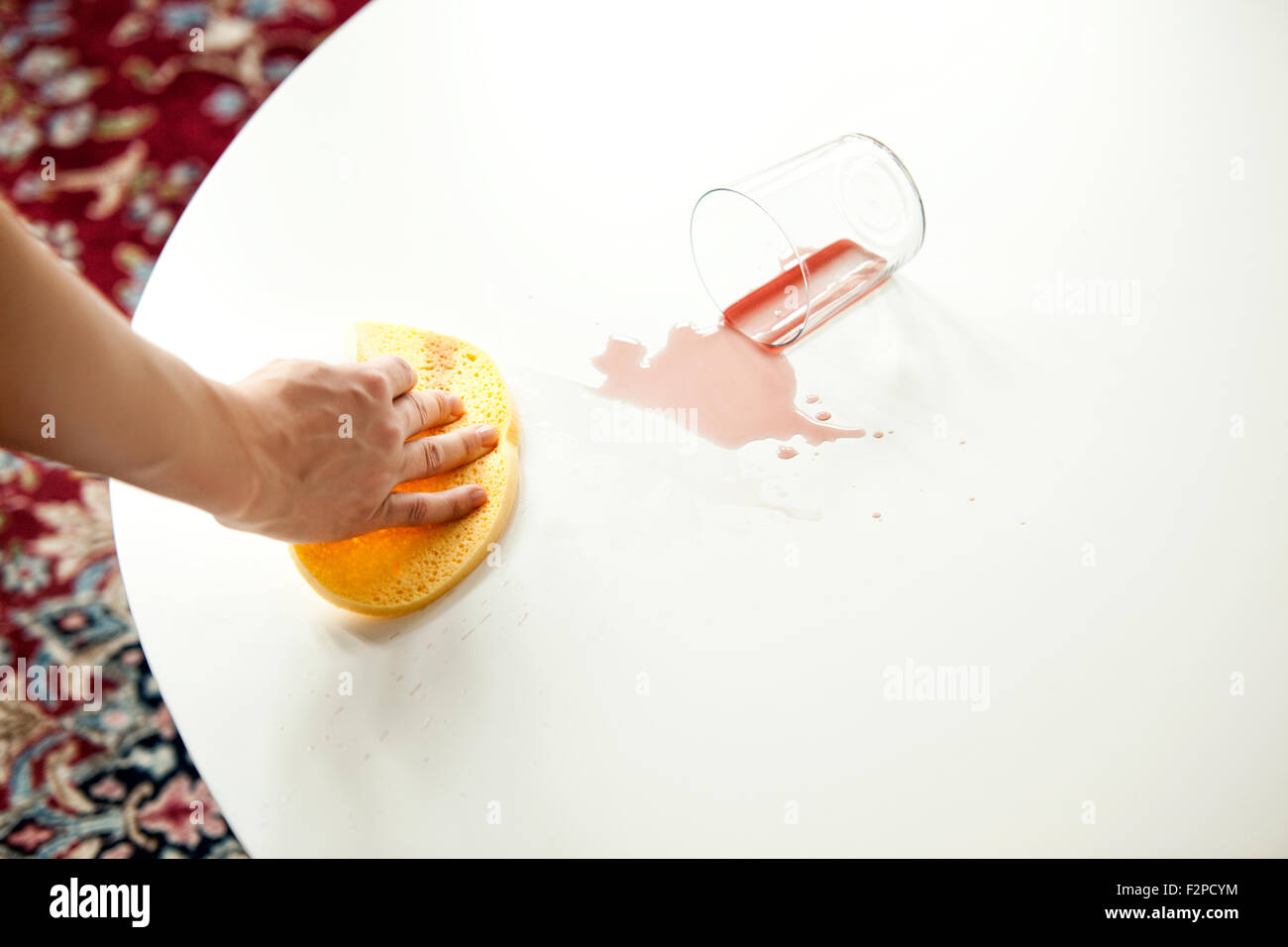 Woman wiping liquid from table from glass fallen down Stock Photo - Alamy