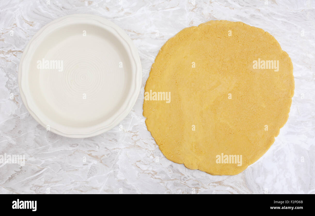 Fresh shortcrust pastry rolled out in a circle, ready to line ceramic ...