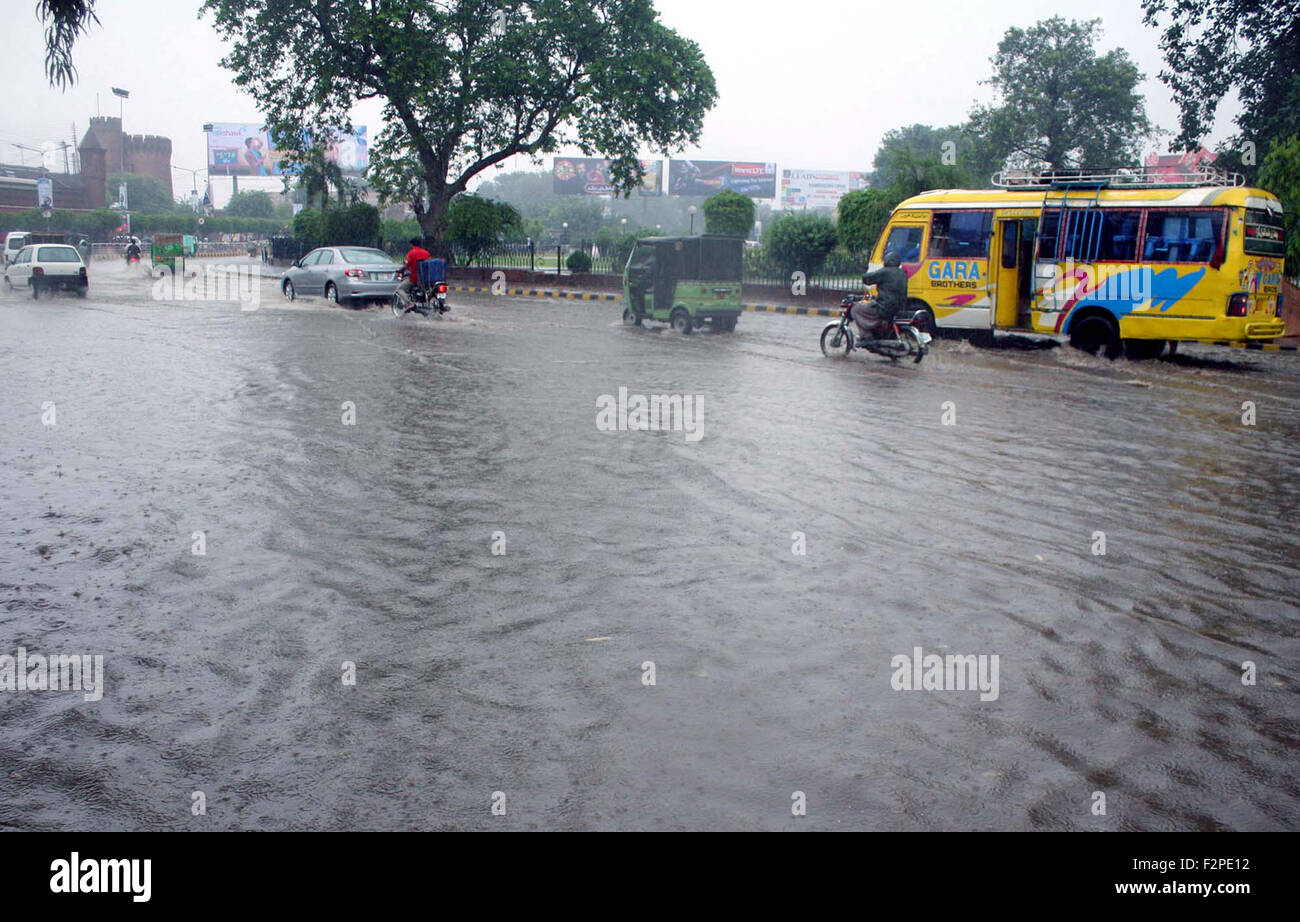Commuters are passing through the stagnant rain water on road after ...