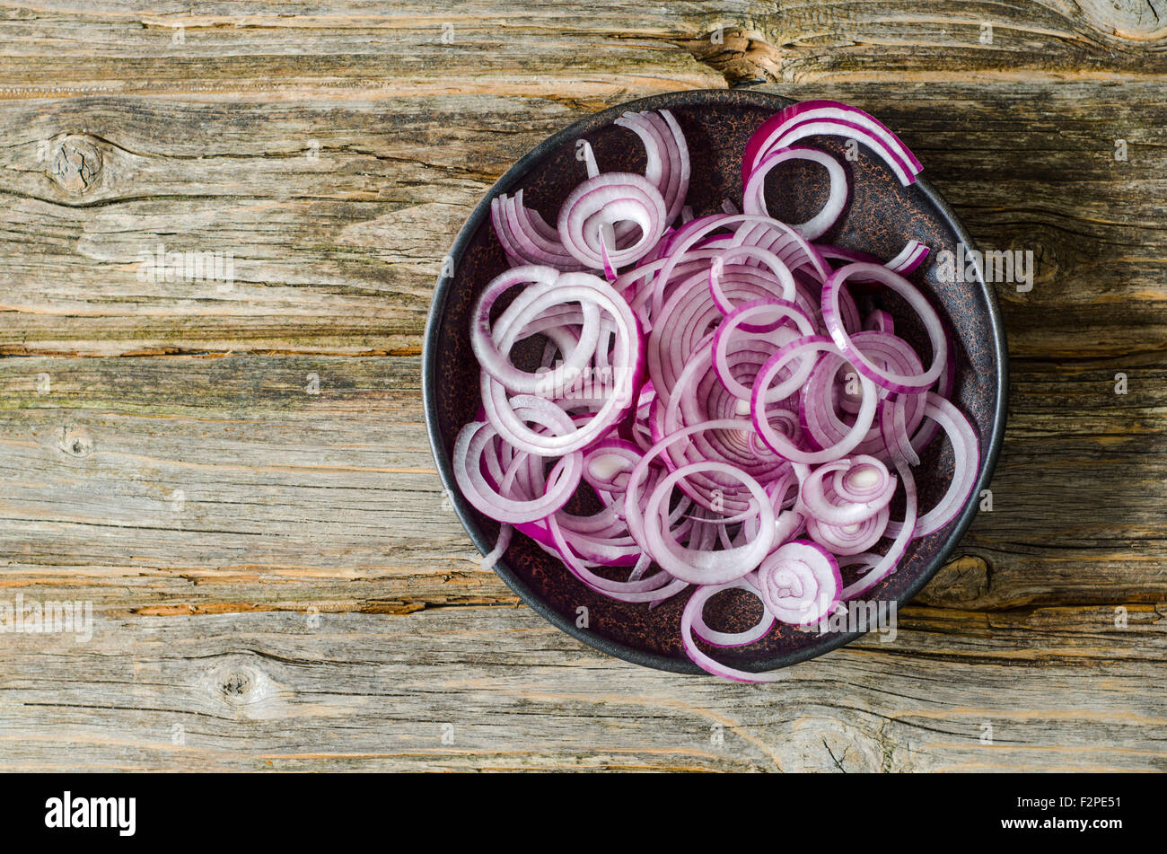 Bowl of sliced red onions on wood Stock Photo - Alamy
