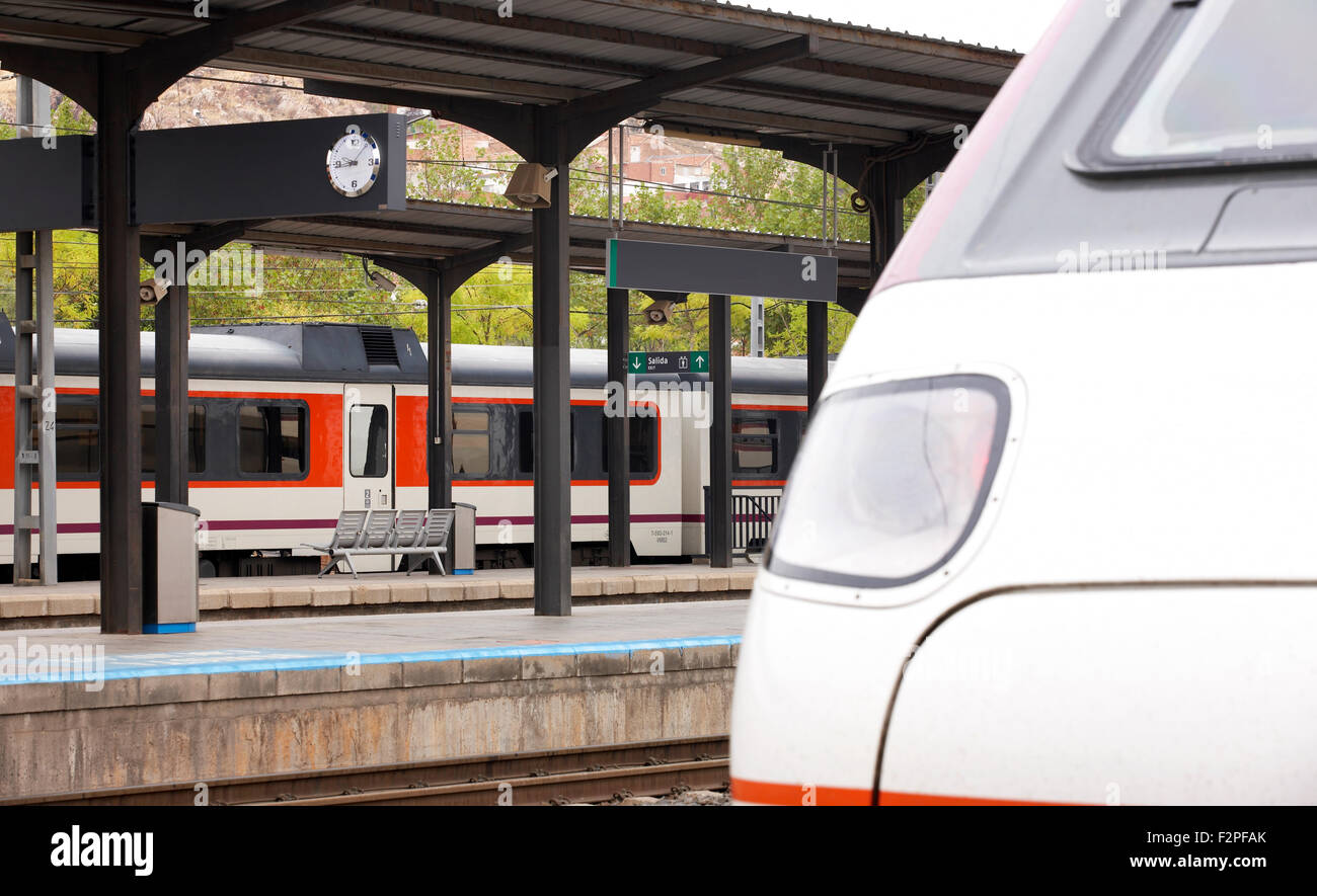 Railway station with trains, platforms and signpost Stock Photo - Alamy