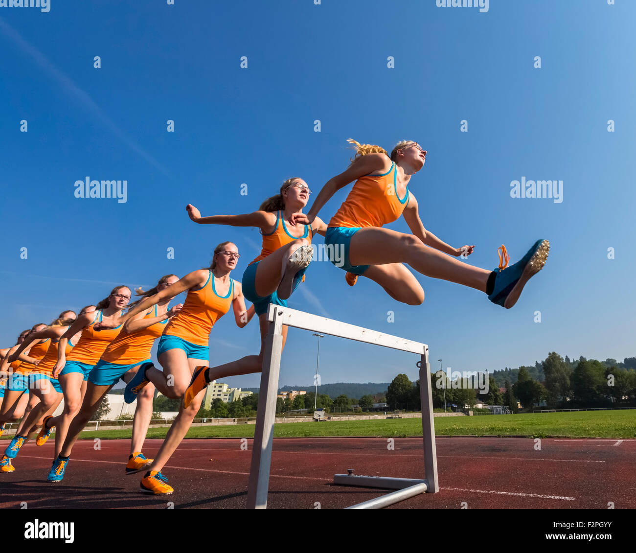 Multiple image of female hurdler jumping over hurdle Stock Photo - Alamy
