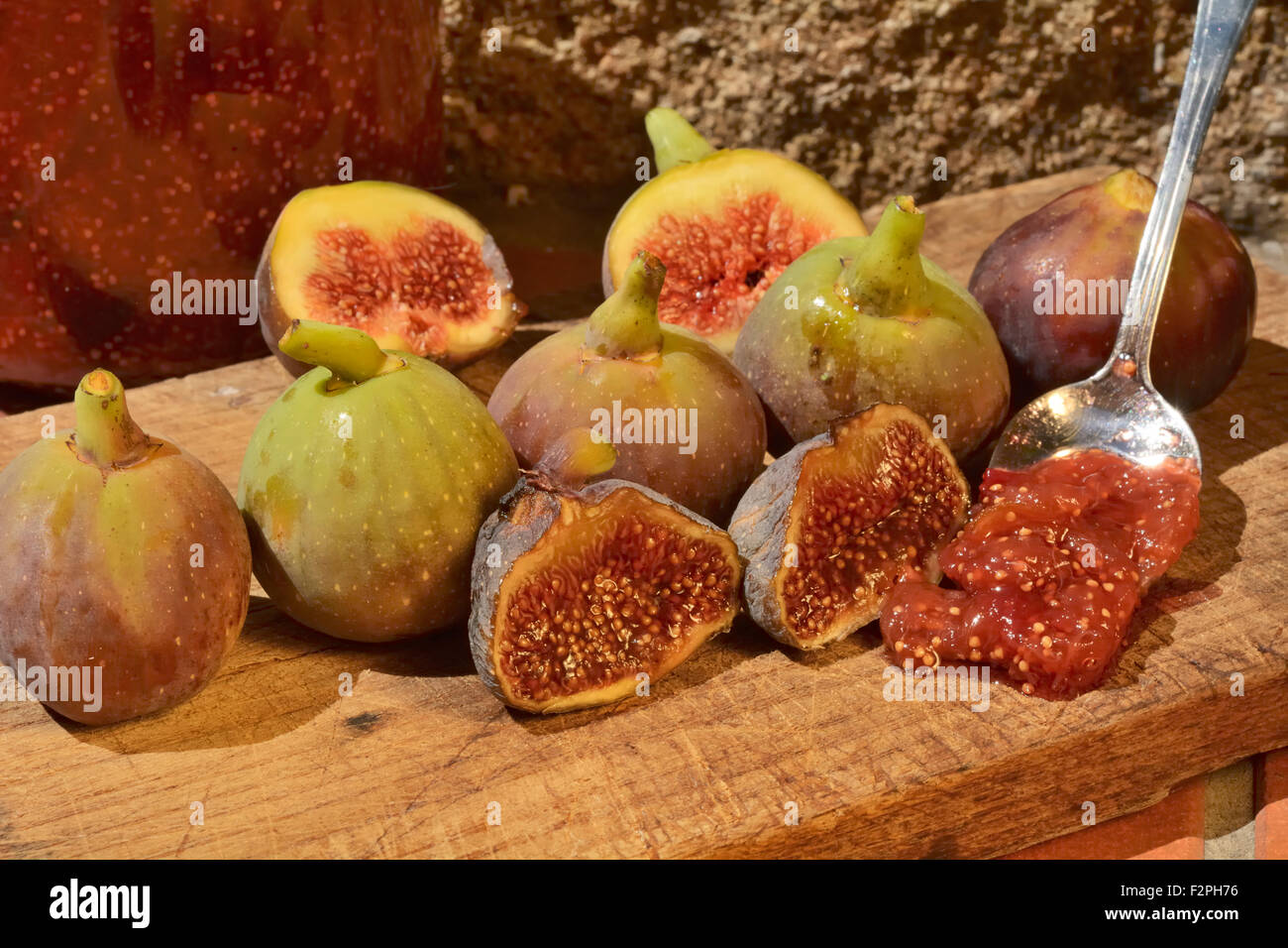 Composition of fig fruits on a wooden board and rocks in the background ...