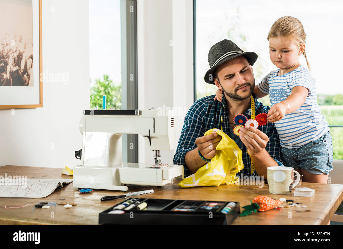Father with and daughter sewing at home Stock Photo - Alamy