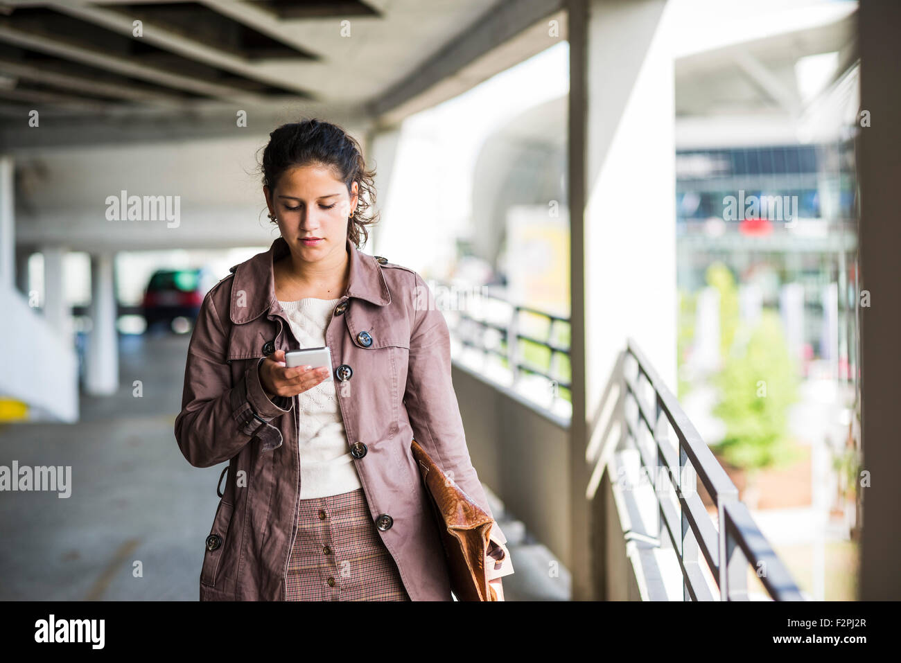 Young woman using smart phone in parking garage Stock Photo - Alamy