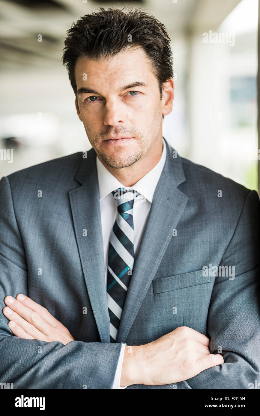 Portrait of serious looking businessman wearing grey suit Stock Photo ...