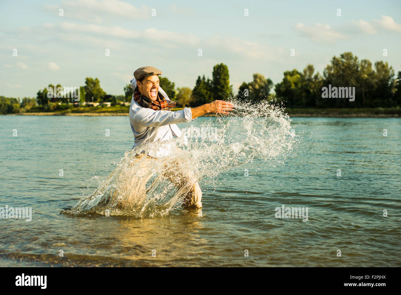 Man standing in the river splashing with water Stock Photo - Alamy