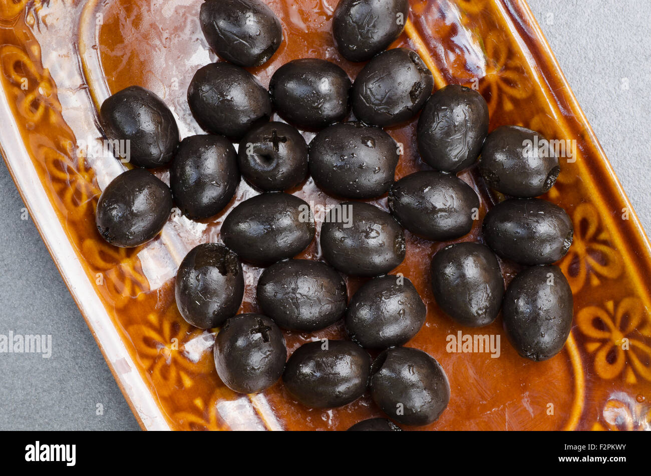 black olives on brown plate Stock Photo - Alamy