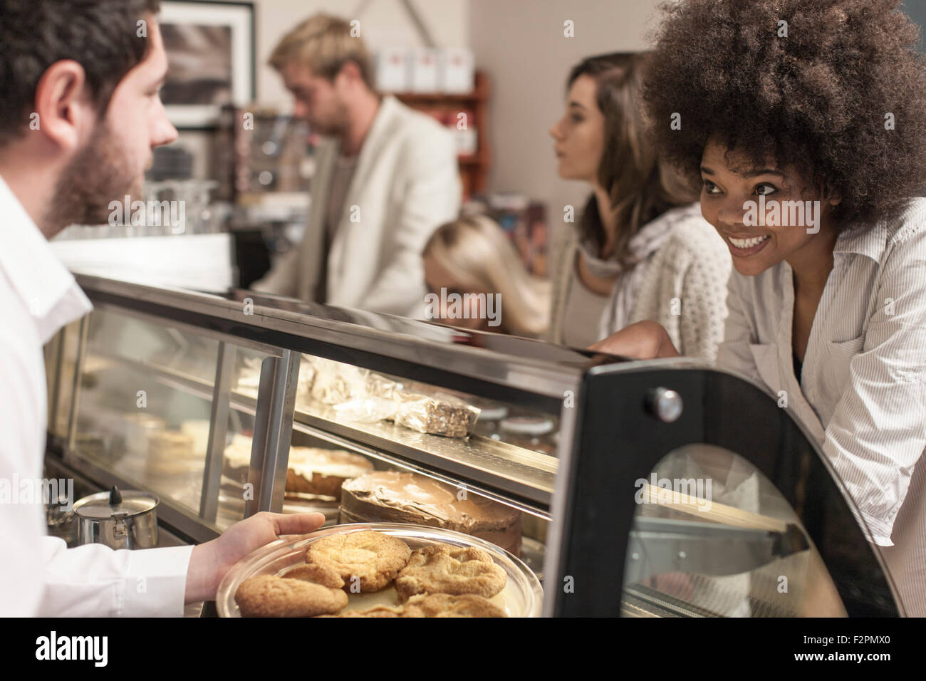 Young women choosing cake from cake counter in coffee shop Stock Photo ...