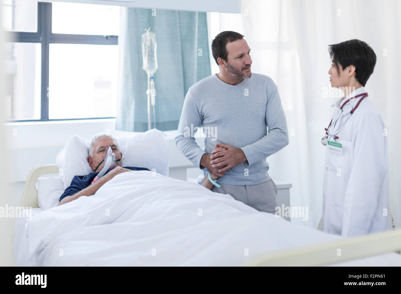 Doctor talking to man visiting patient in hospital Stock Photo - Alamy