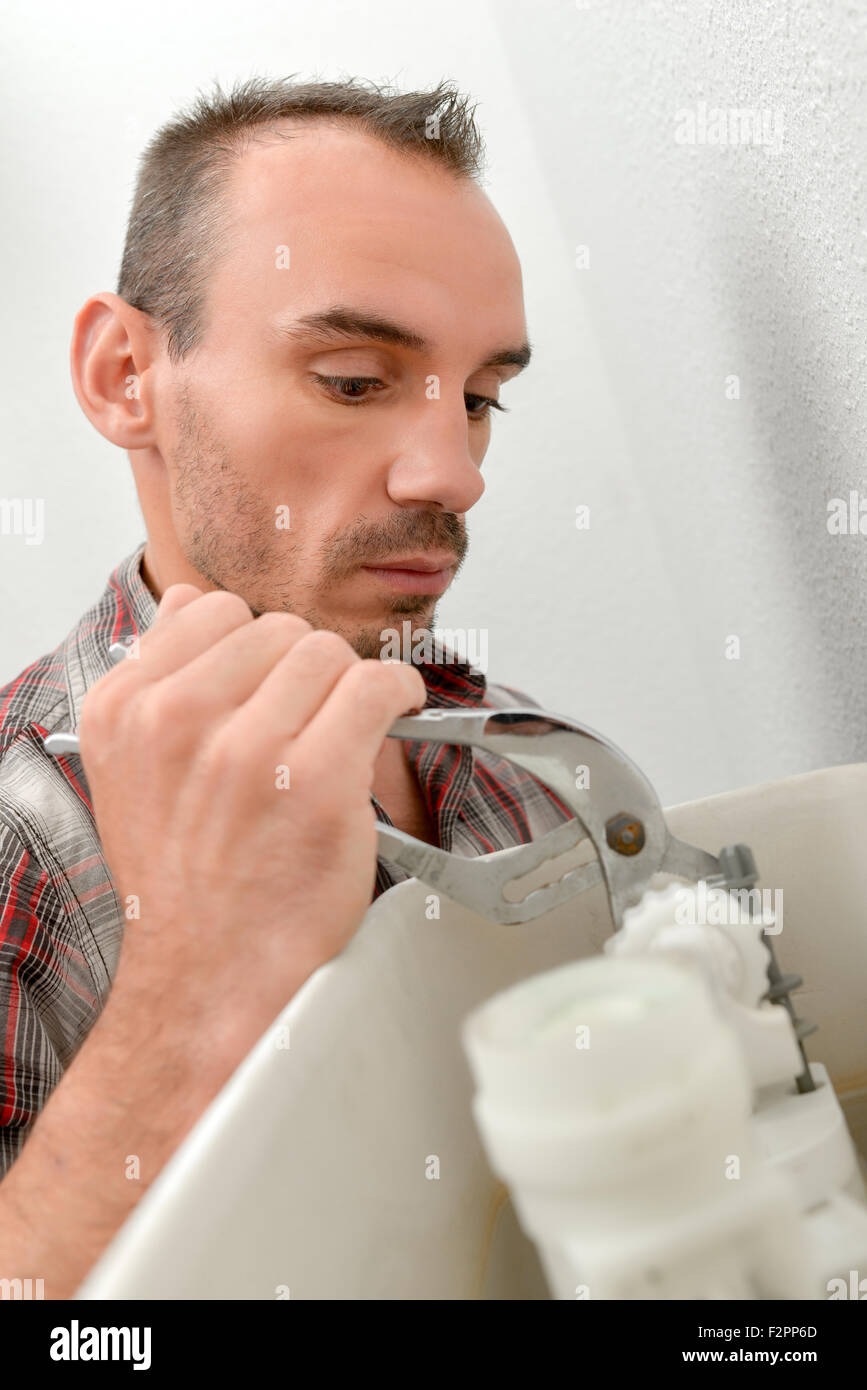 Plumber repairing a toilet Stock Photo - Alamy