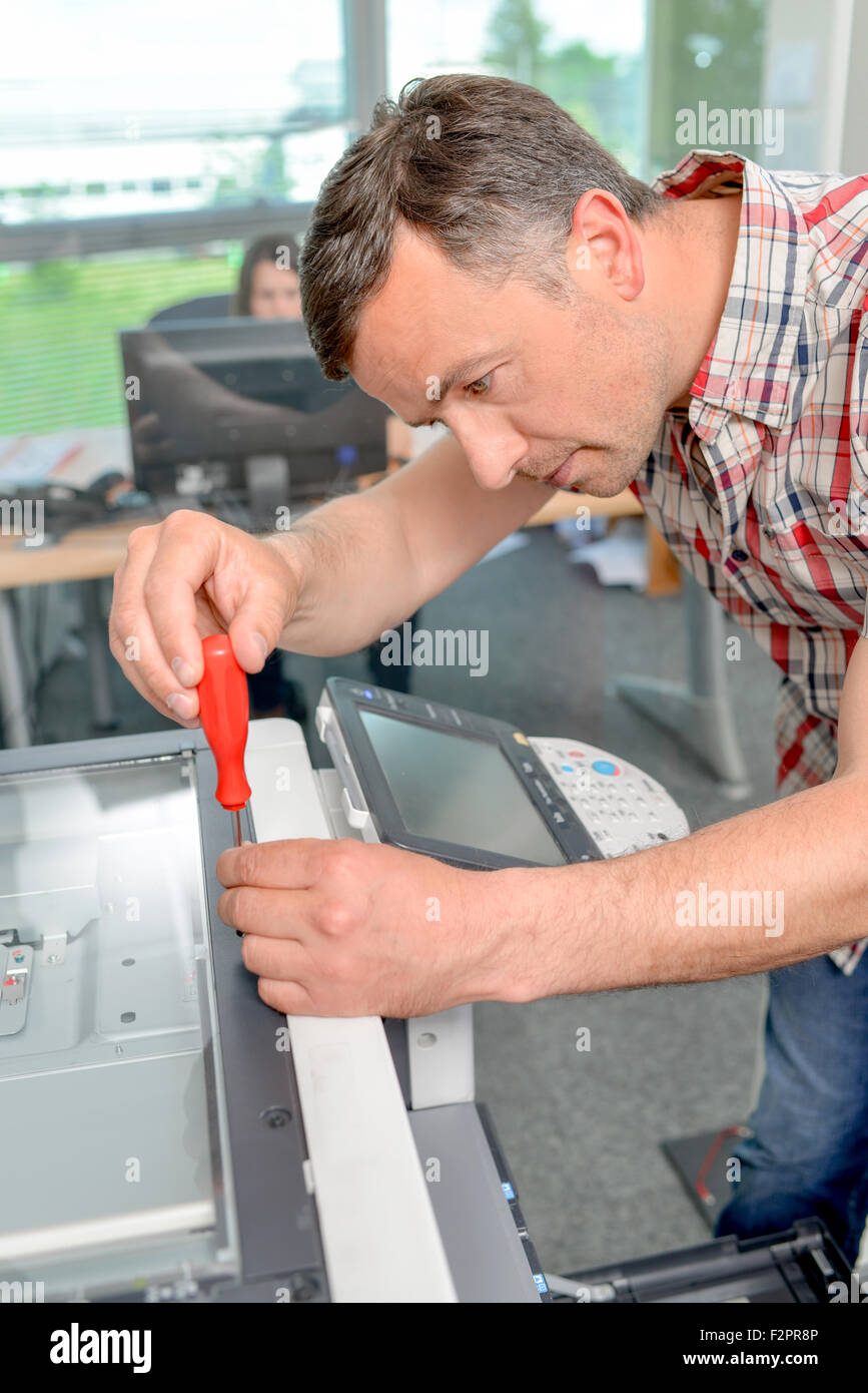 Man trying to repair the office printer Stock Photo - Alamy