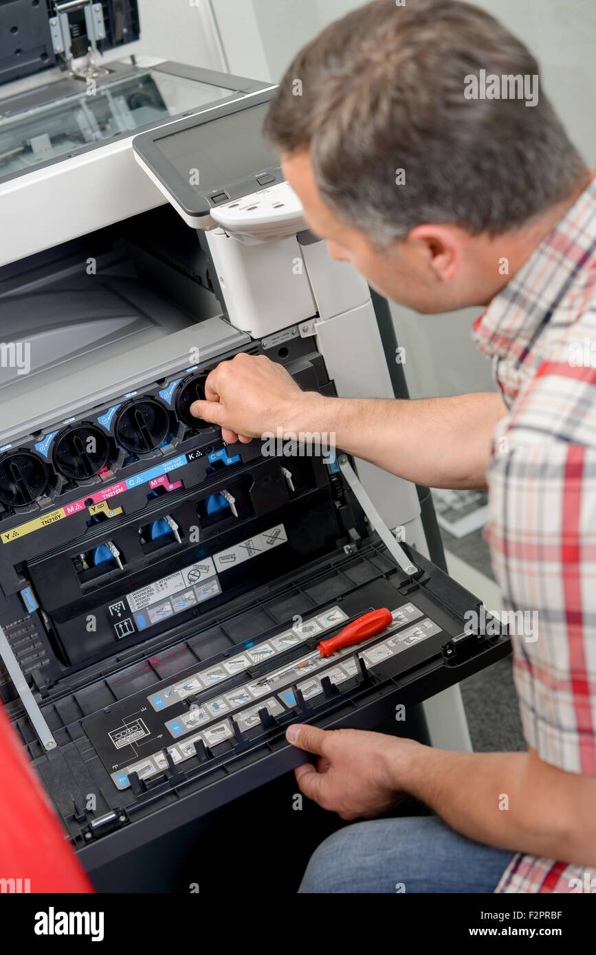 Man working on photocopier Stock Photo - Alamy