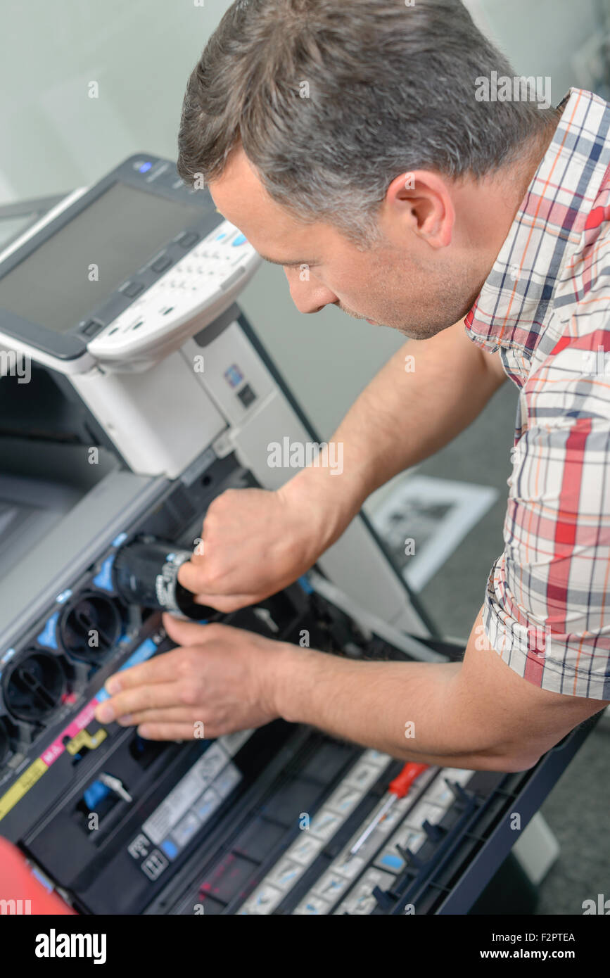 Man repairing a printer Stock Photo - Alamy