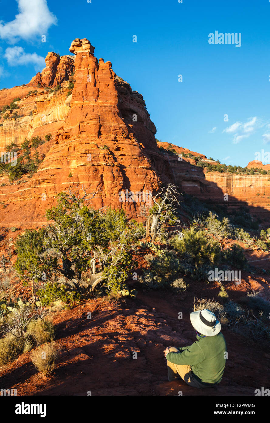 Resting hiker gazes at Kachina Woman in Sedona at sunset Stock Photo ...