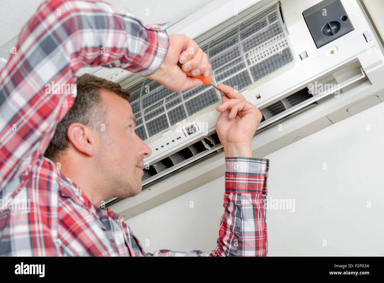 Man working on air conditioning unit Stock Photo - Alamy