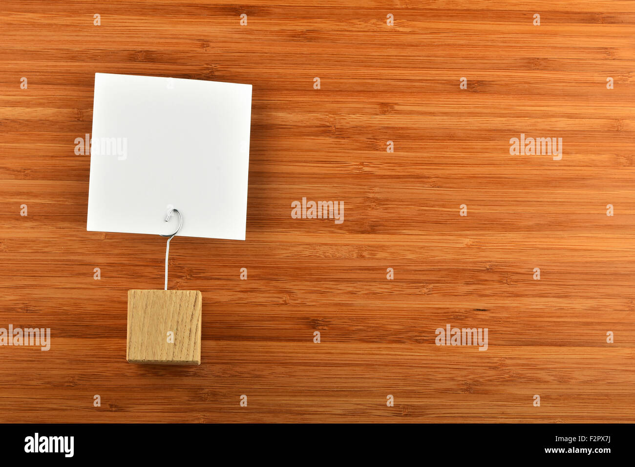 One single white paper note with wooden holder on bamboo wooden ...