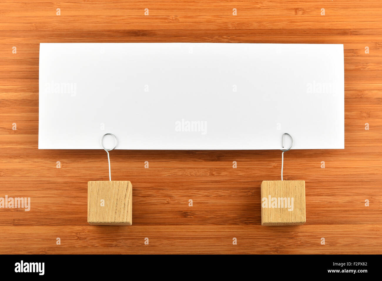 Together, one big white paper note with two wooden holders on wooden ...