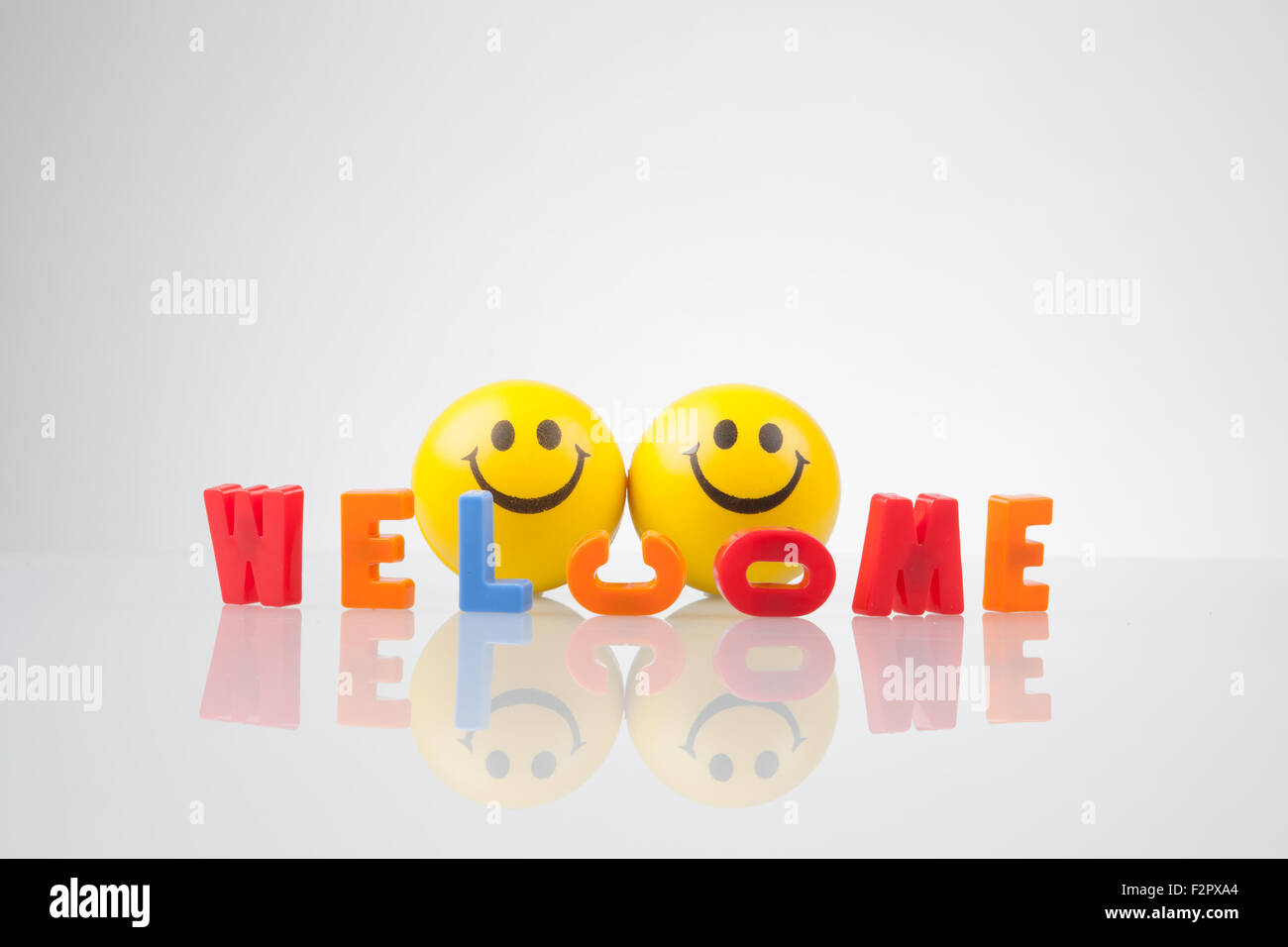 Welcome sign with two smileys on white background Stock Photo - Alamy